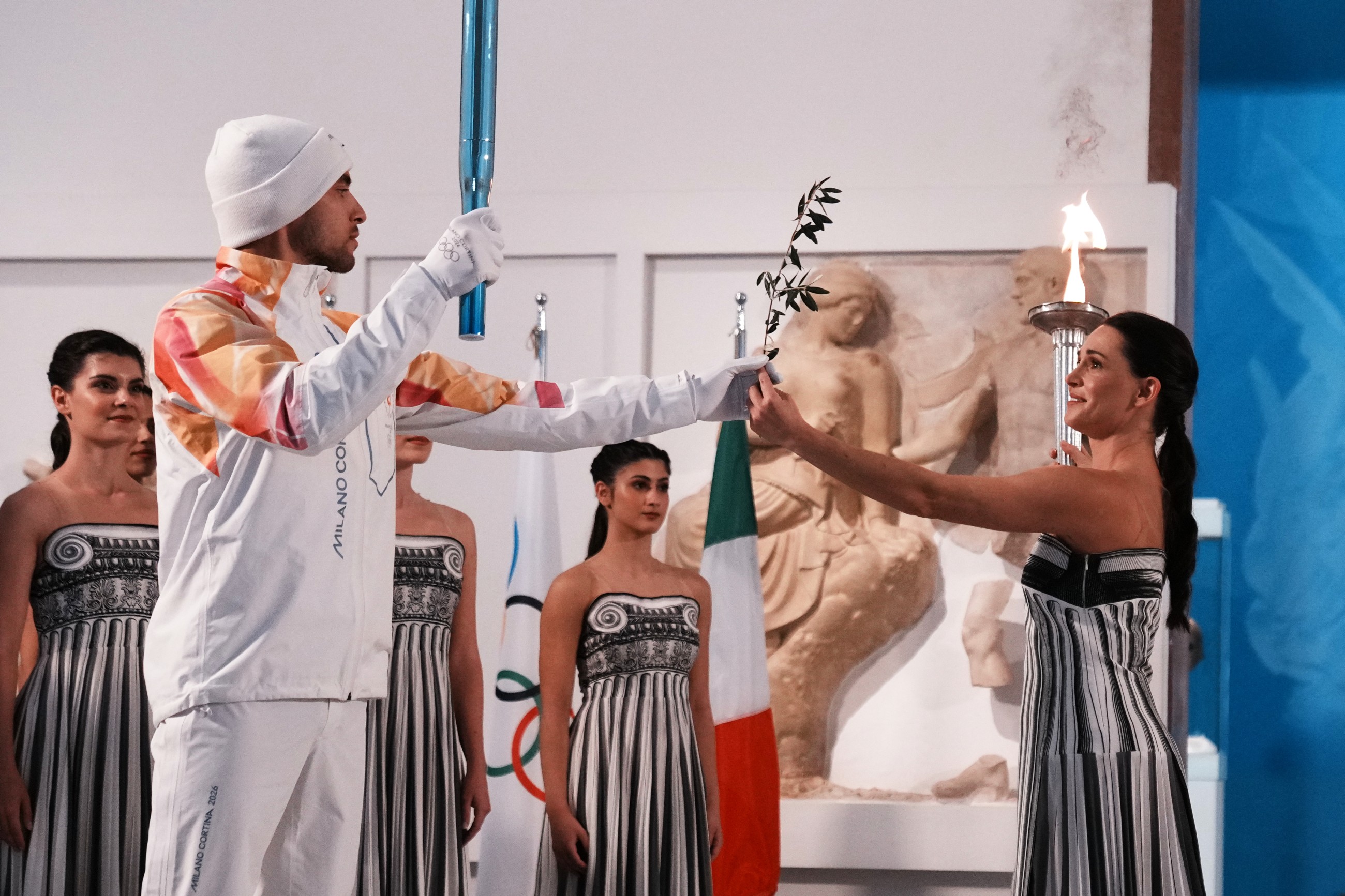 Under a cloud, the Olympic flame begins its journey to th...